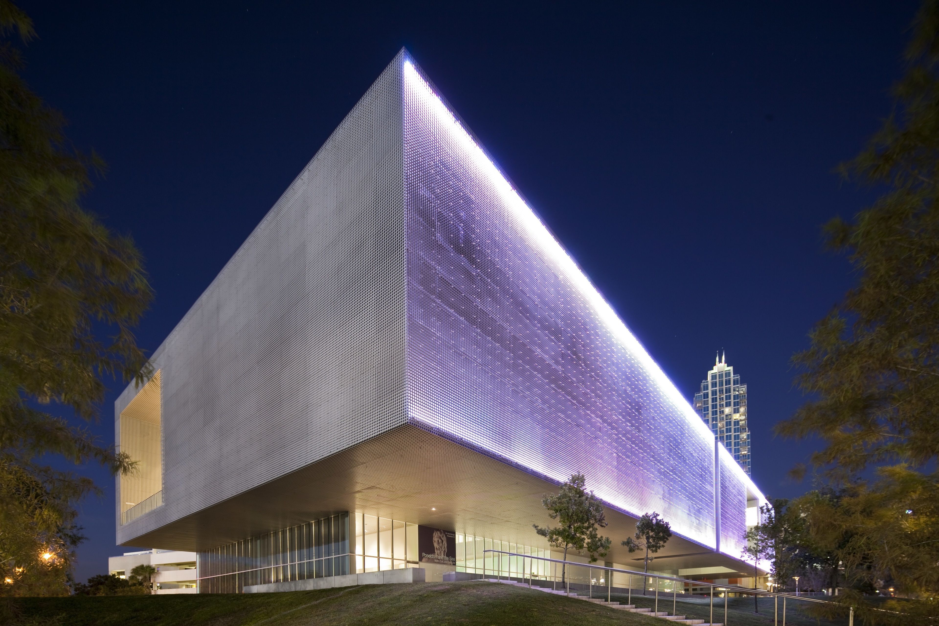 Um edifício moderno com uma fachada grande e iluminada à noite.