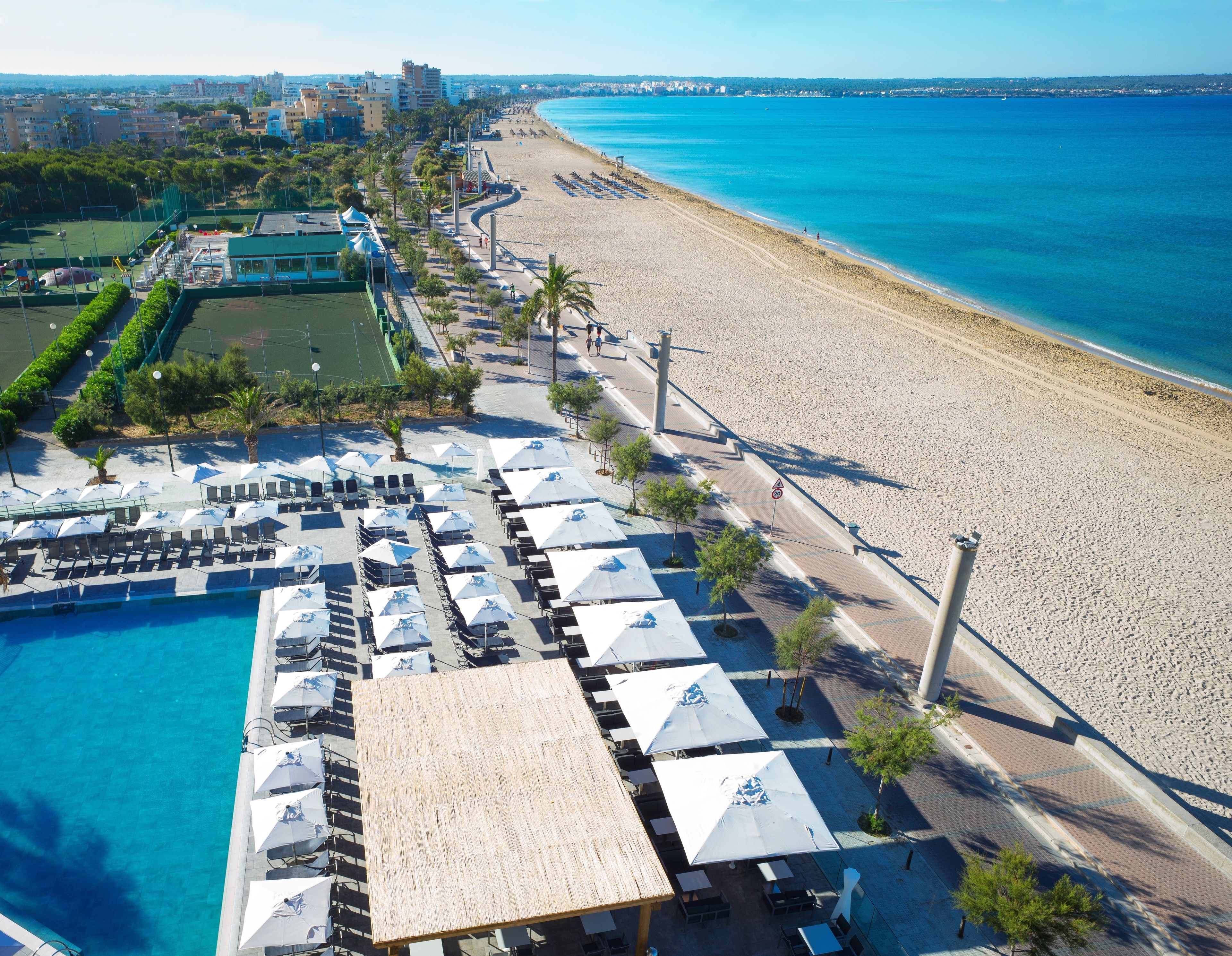 Um resort com área de piscina, acesso à praia e vista para o oceano.