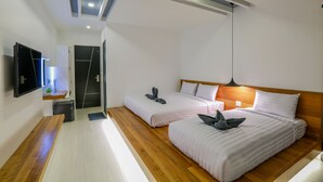 Quarto de hotel moderno com duas camas, um banco de madeira, televisão de tela plana e luminária no teto.