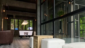 Um interior moderno com piso xadrez, um sofá branco, um caixa de madeira e um banquinho branco.