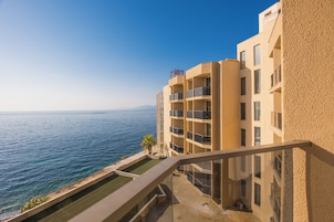 Hotel com vários andares e varandas com vista para a água.
