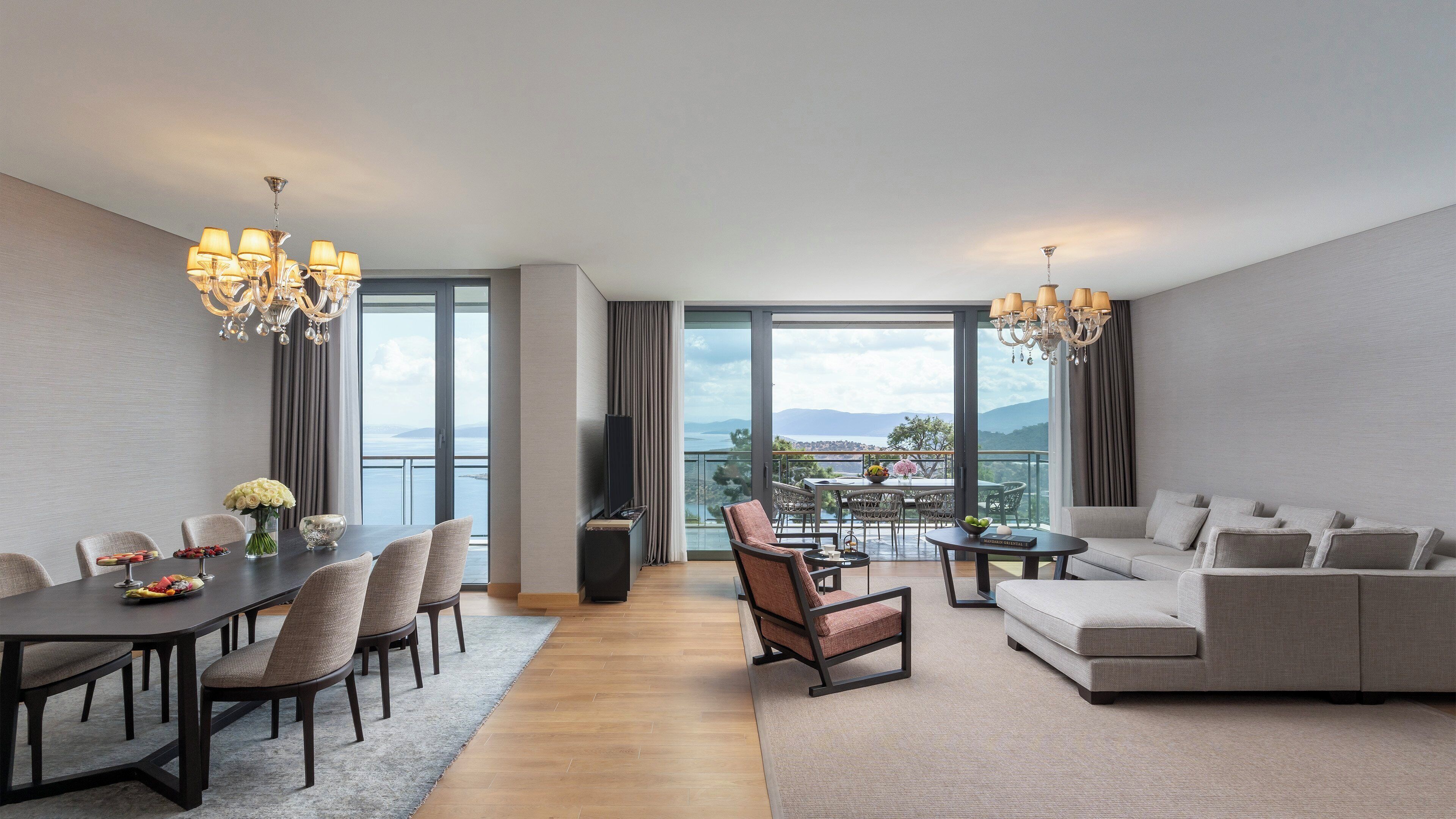 Uma sala de estar moderna com área de jantar, um sofá e uma varanda com vista.