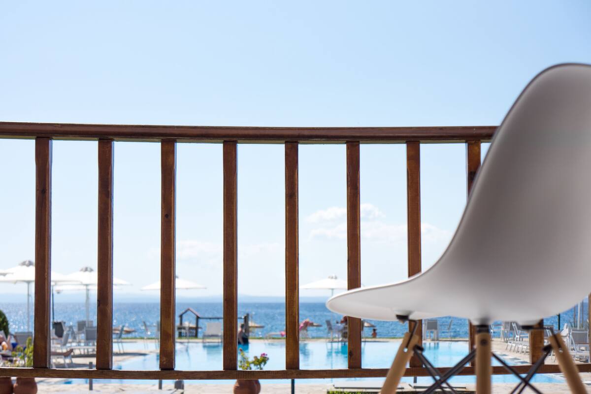 Varanda com vista para uma piscina e o oceano.