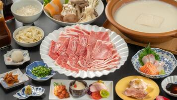 Diversos pratos japoneses, incluindo sashimi, macarrão e um pote quente.