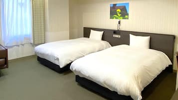 Quarto de hotel com duas camas, uma escrivaninha e uma janela com cortinas.