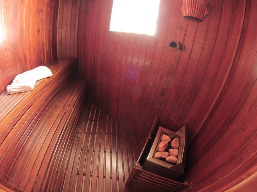 Uma sala de sauna com paredes e bancos de madeira.