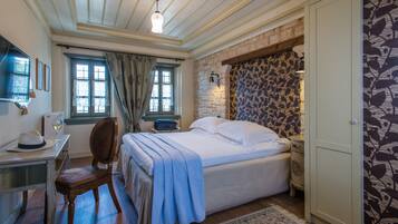 Quarto com cama, escrivaninha, cadeira, mesa de cabeceira e guarda-roupa.