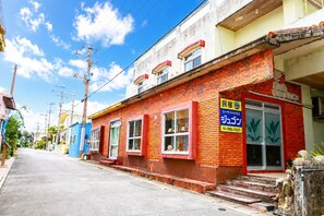 Edifício de tijolos vermelhos com fachada azul e número de telefone visível.