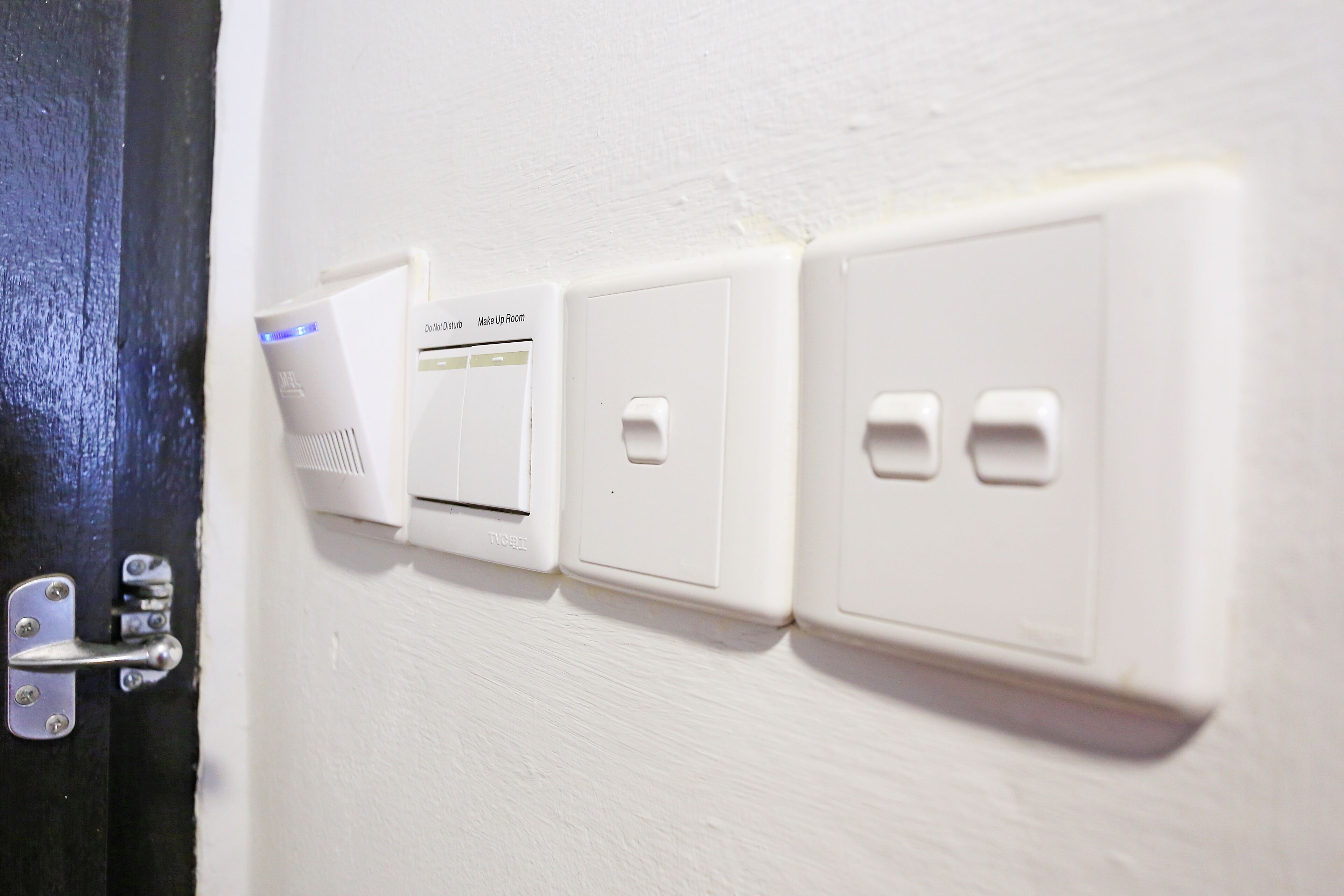 Uma tomada elétrica fixa na parede, com termostato e interruptor de luz.