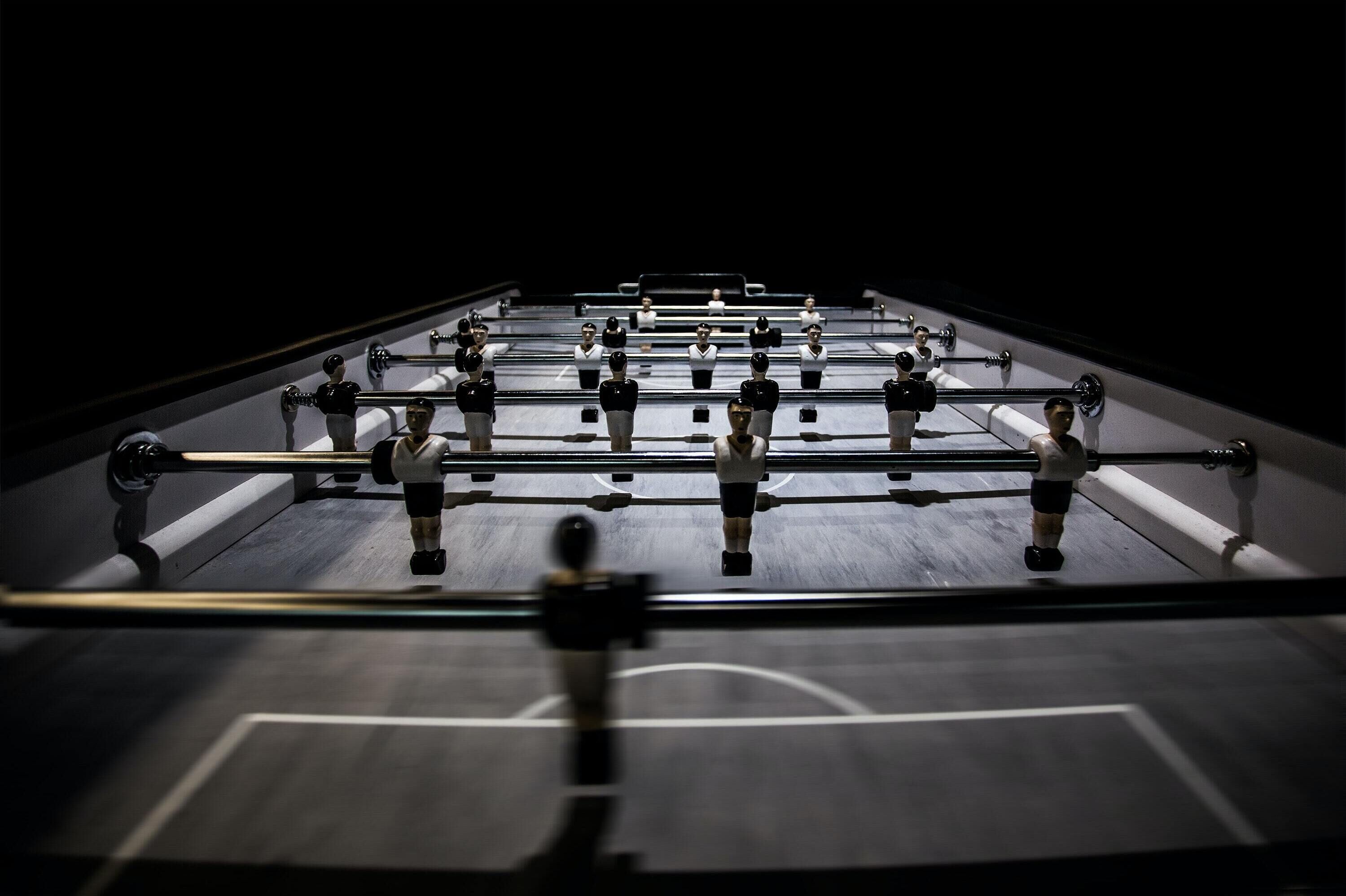Uma mesa de futebol em um ambiente com pouca luz.