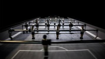 Uma mesa de futebol em um ambiente com pouca luz.