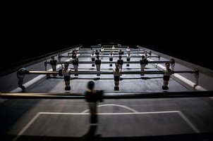 Uma mesa de futebol em um ambiente com pouca luz.