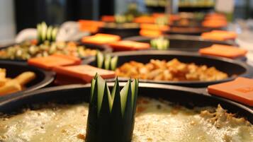 Buffet com diversos pratos, incluindo um prato principal com detalhe decorativo.