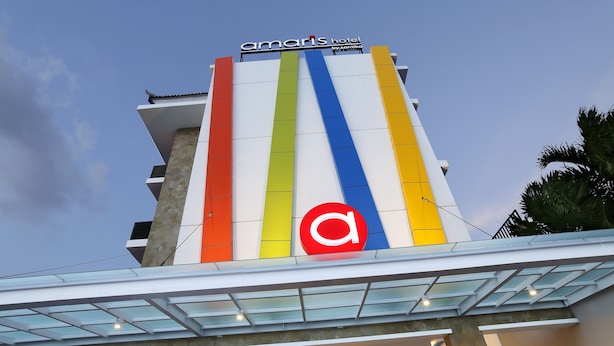 Um hotel com design de faixa vertical colorida e um logotipo 'a' em destaque.