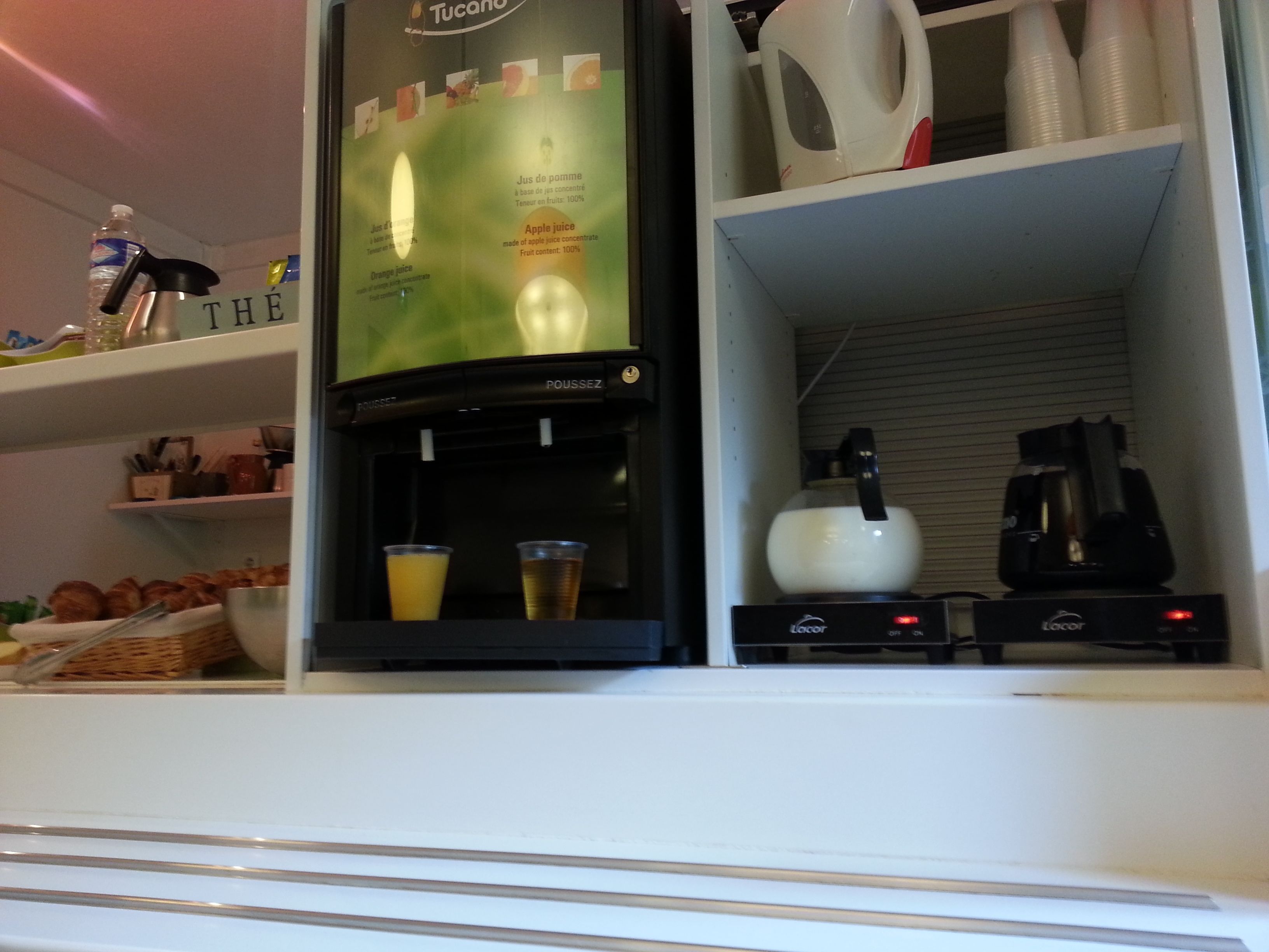 Dispensador de bebidas com opções de suco de maçã e suco de laranja.