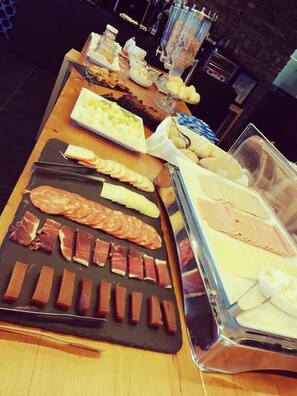 Um buffet com diversos tipos de carne e queijo.