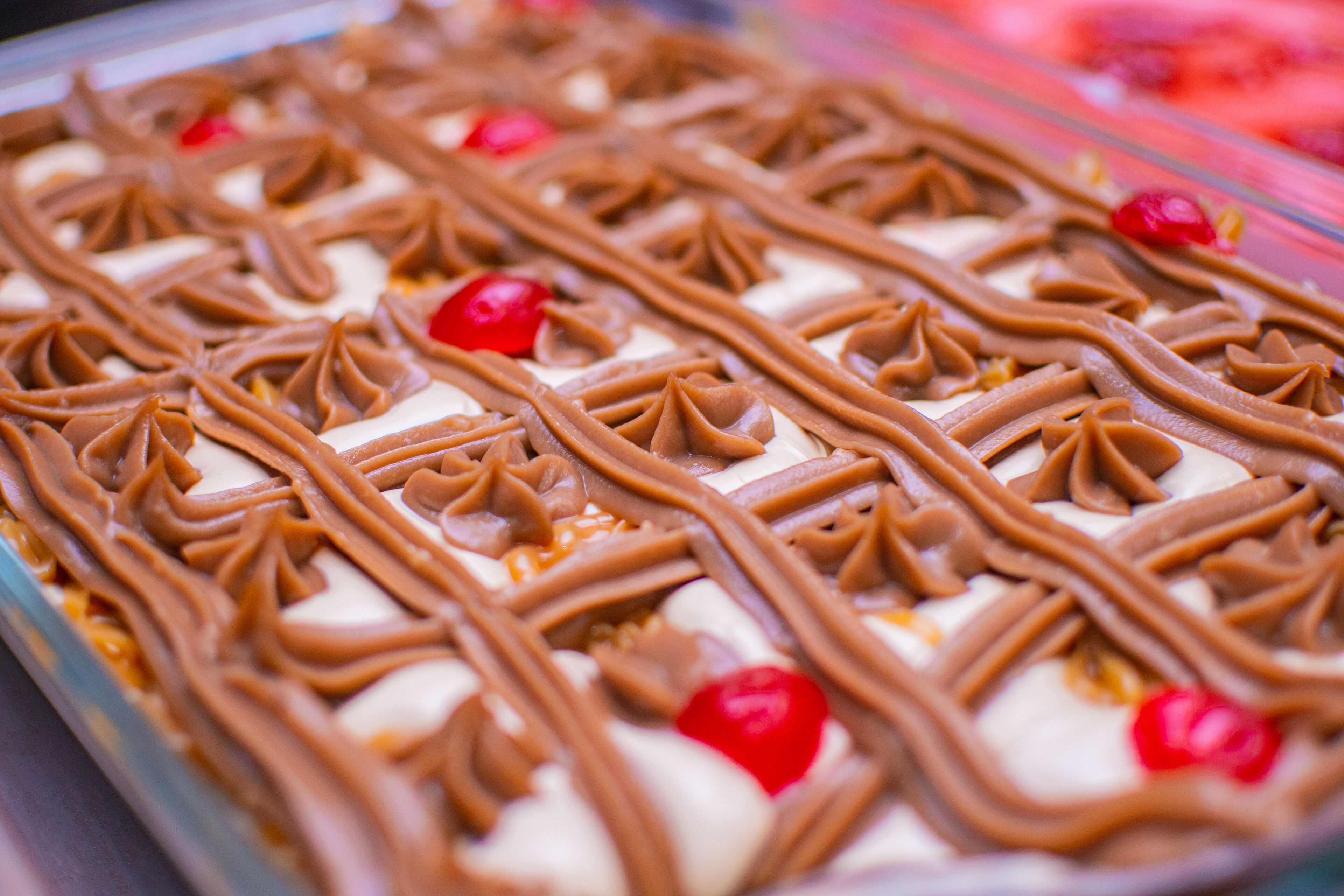 Uma sobremesa com redemoinhos de chocolate e cerejas.
