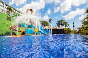 Piscina com escorregador e escadaria que dá acesso a uma plataforma.