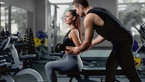 Uma academia com diversos equipamentos de exercício, incluindo halteres e máquinas de musculação.