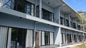 Um hotel moderno com piscina, janelas amplas e estrutura em dois andares.