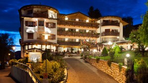 Um hotel com vários andares e arquitetura europeia tradicional, com varandas e fachada de pedra.