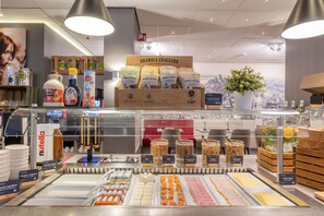 Uma área de exposição de alimentos com diversos lanches embalados e produtos lácteos.