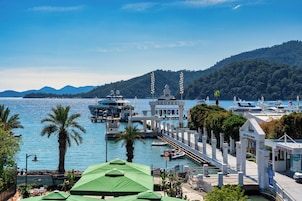 Uma marina com barcos, um restaurante e uma placa com a inscrição 'SKOPEA'.