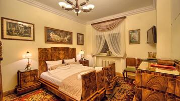 Um quarto tradicional com uma cama de dossel, um candelabro e um espelho grande.