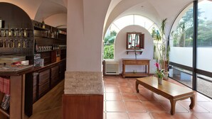 Cozinha espaçosa com bancada comprida, banco de madeira e uma janela grande com vista para o exterior.
