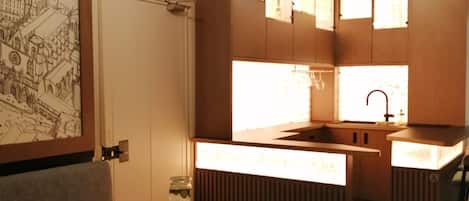 Uma cozinha moderna com armários de madeira, uma ilha integrada e um espaço de refeições com bancos.
