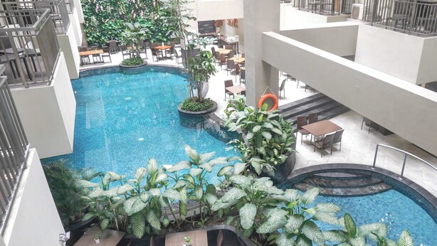 Piscina interior com assentos e plantas ao redor.