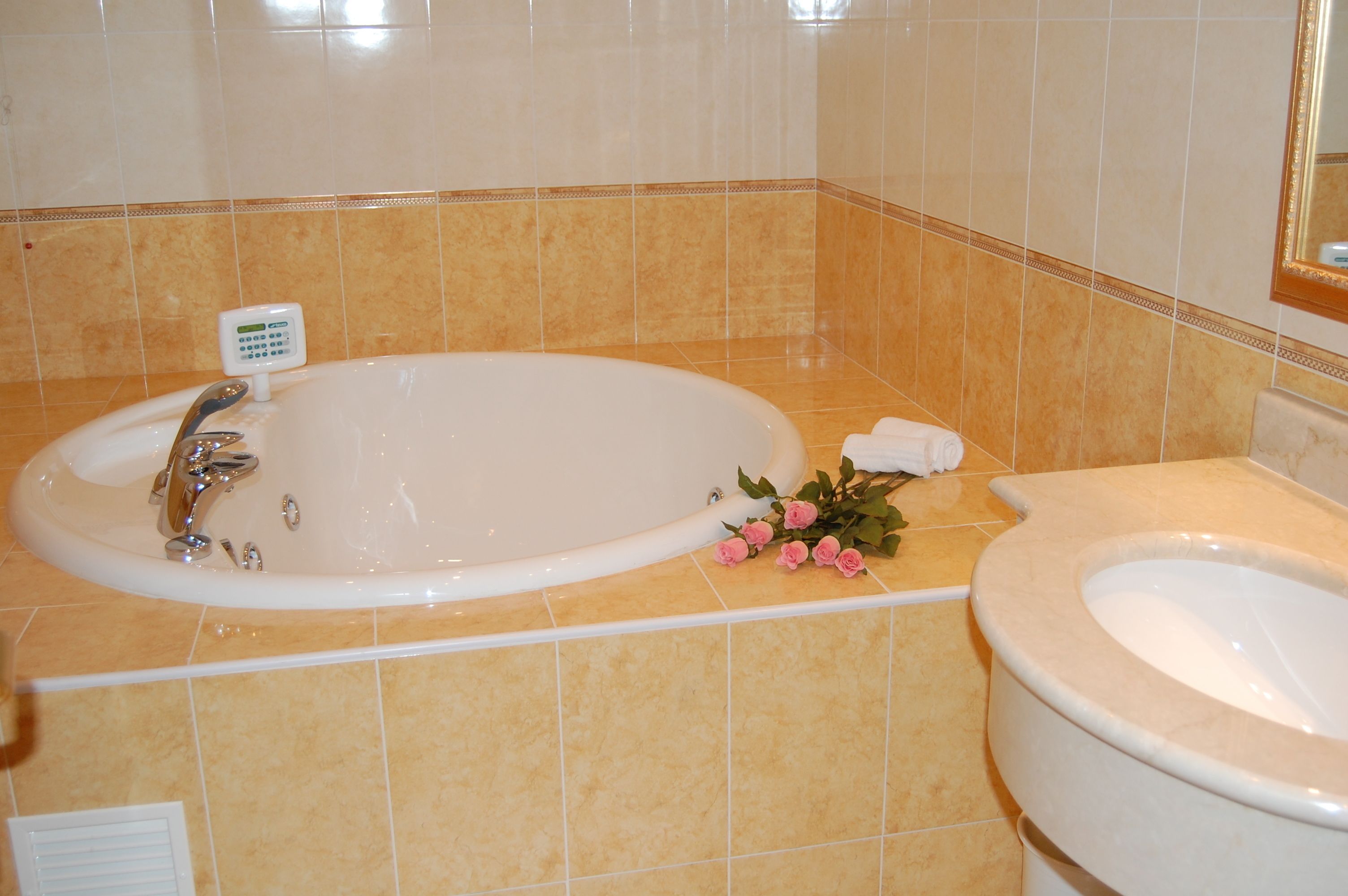 Casa de banho com banheira, sanita e dispensador de gel desinfetante.