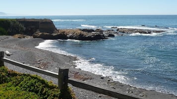Na praia, praia de areia negra, toalhas de praia