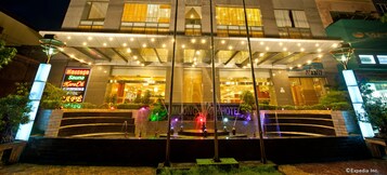 Um hotel com piscina, instalações de massagem e sauna, e um café.