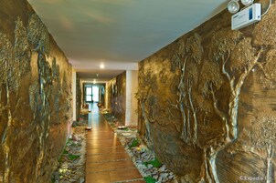 Um corredor com caminho de pedra e arte decorativa na parede.