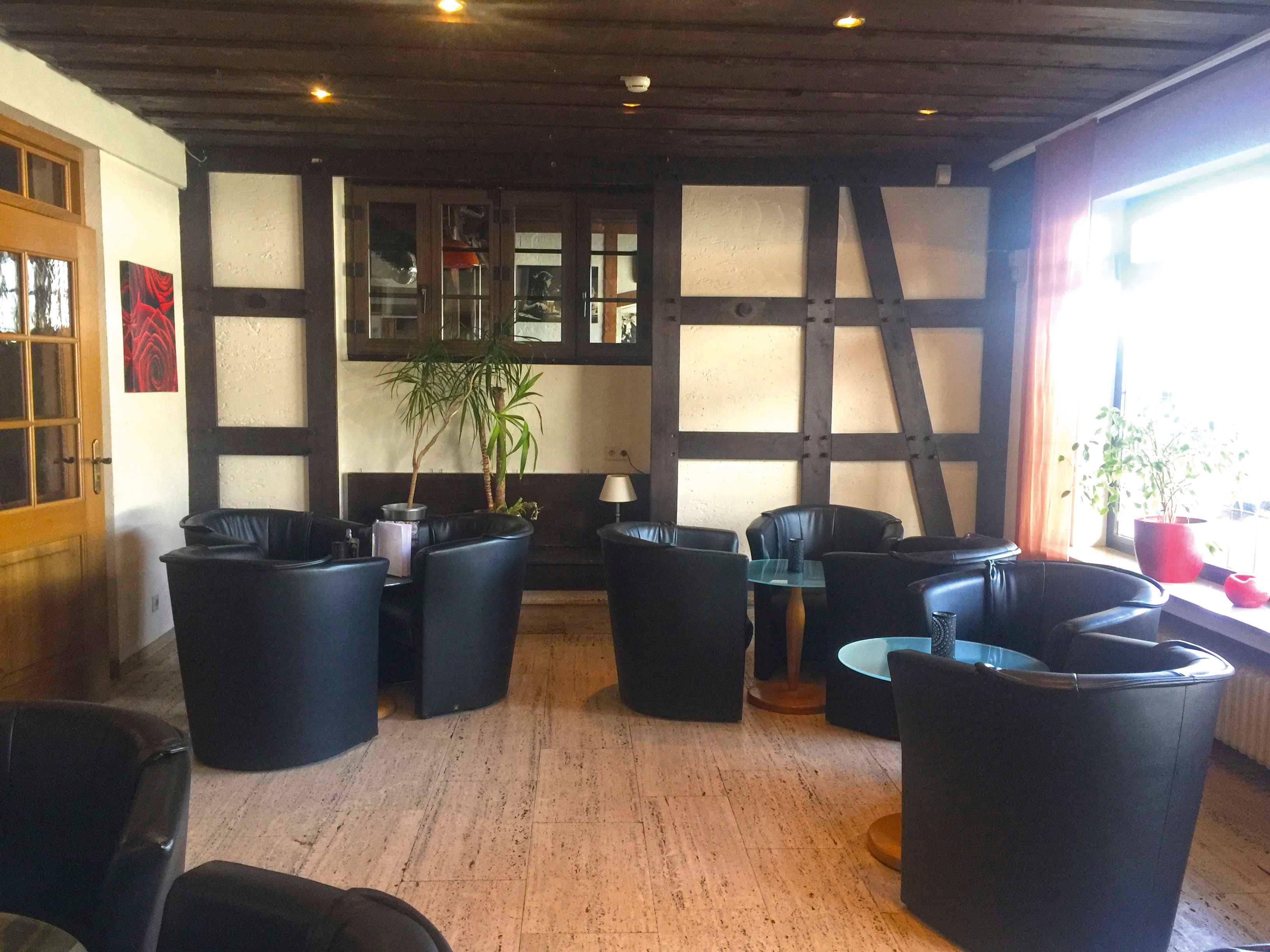 Um interior acolhedor, com vigas de madeira, assentos de couro preto e uma grande janela com vista.