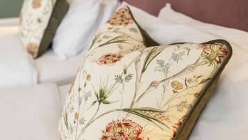 Cama com almofadas estampadas e cabeceira.