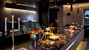 Um buffet com diversos alimentos e um castiçal decorativo.
