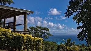 Uma área de estar coberta ao ar livre, com vista para o oceano.
