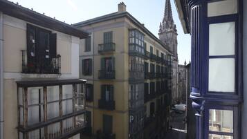 Uma rua estreita com edifícios altos, incluindo uma igreja com uma torre.
