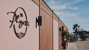 Um edifício com fachada de madeira e uma placa com a inscrição 'Playa'.