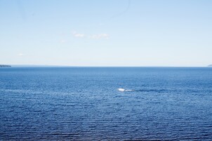 Mar calmo com um barco ao longe.