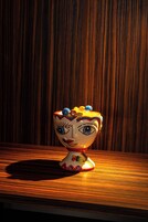 Uma figura de cerâmica sobre uma superfície de madeira, com fundo de madeira.