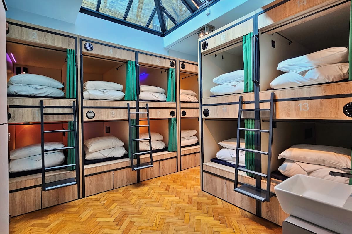 Um quarto estilo dormitório, com beliches, compartimentos numerados e um claraboia.