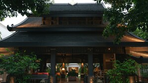 Um edifício japonês tradicional com fachada de madeira e entrada coberta.