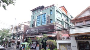 Um edifício de vários andares com uma placa indicando Hotel Pannenee.