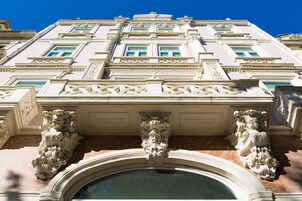 Um edifício imponente com detalhes arquitetônicos requintados, incluindo colunas e molduras decorativas.