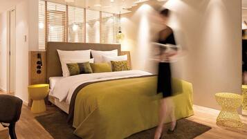 Quarto moderno com cama grande, cabeceira de madeira e parede de destaque amarela.
