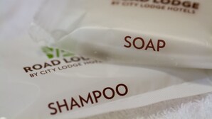 Close-up de um sabonete com o texto "ROAD LODGE BY CITY LODGE HOTELS" e "SOAP" visíveis.