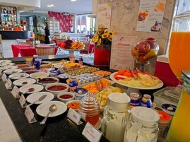 Um buffet com diversos alimentos e acompanhamentos.